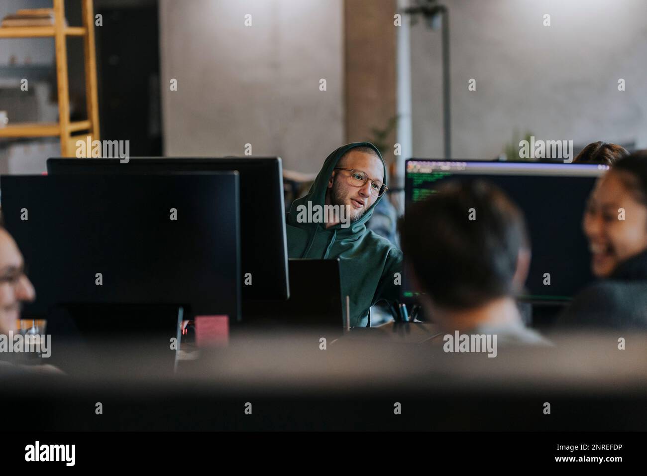 Smiling male and female programmers working on computer at startup ...
