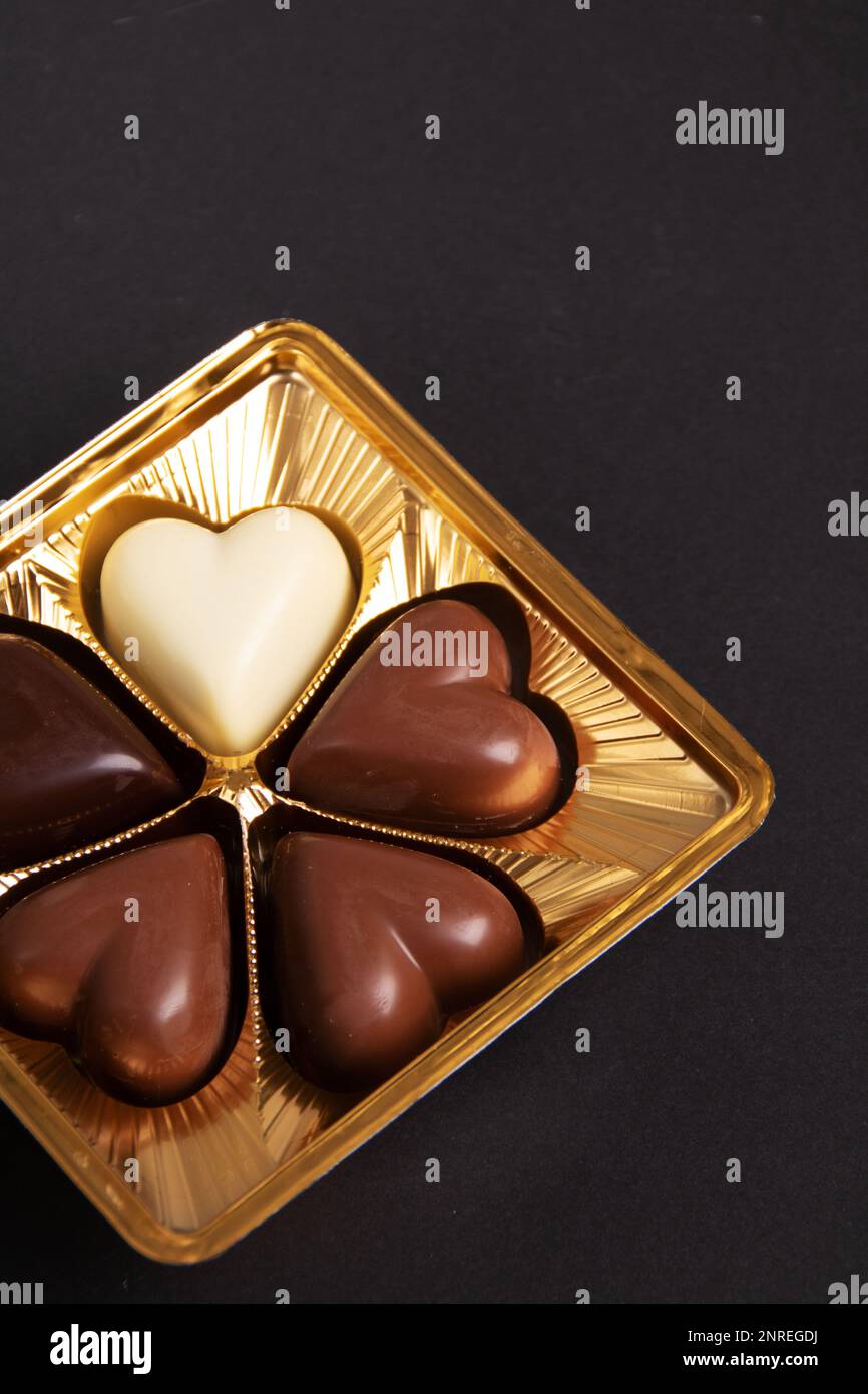 photo chocolates in a package on a black background Stock Photo - Alamy