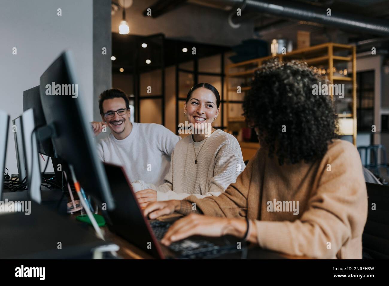 Female computer programmer discussing strategy with happy colleagues at startup company Stock ...
