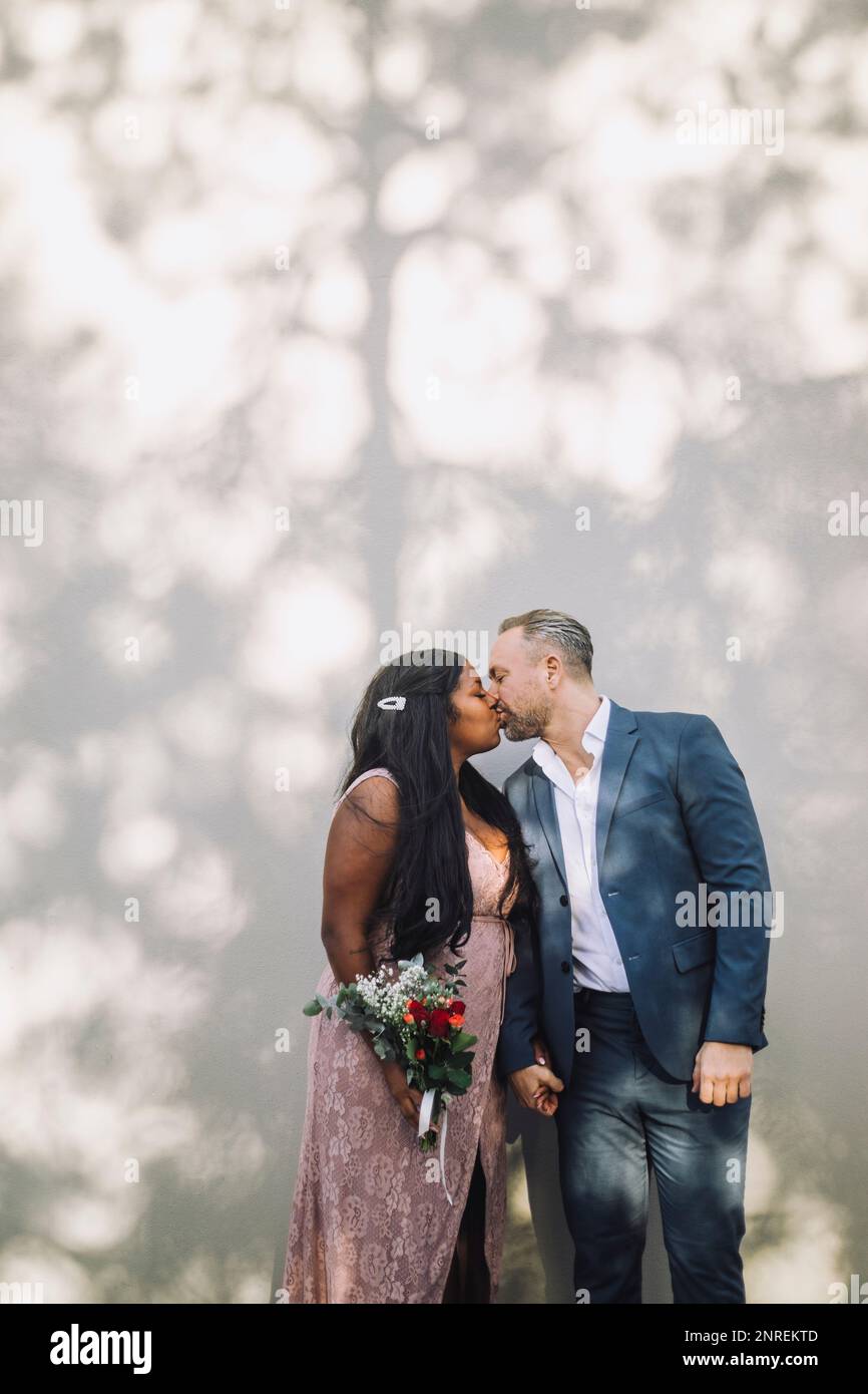 Young couple kissing against wall hi-res stock photography and images ...