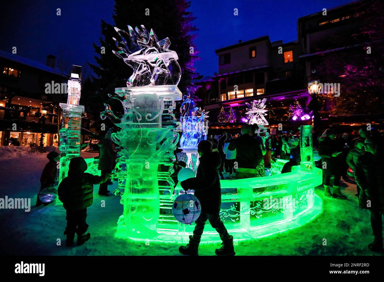 Kids and adults check out the ice castle after the lantern walk Sunday ...