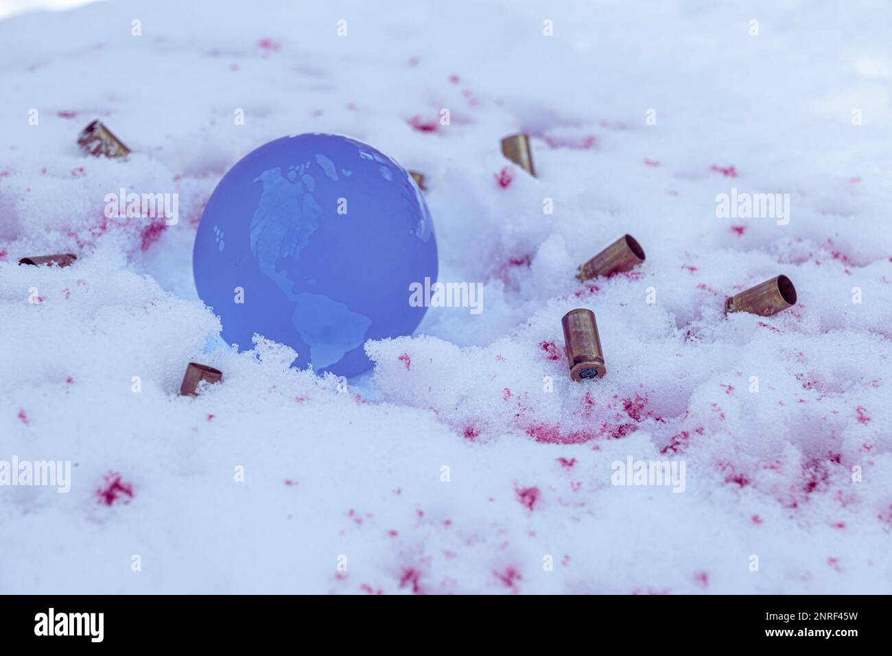 The concept of symbolism. crystal earth globe on snow with blood stains ...