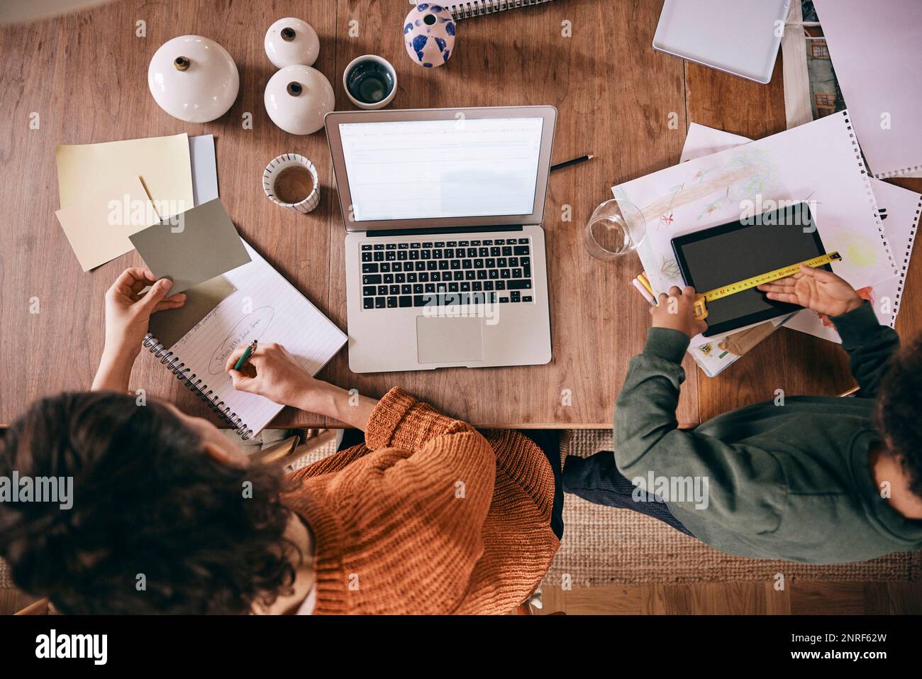 High angle of freelancer writing in diary while holding letter by son ...