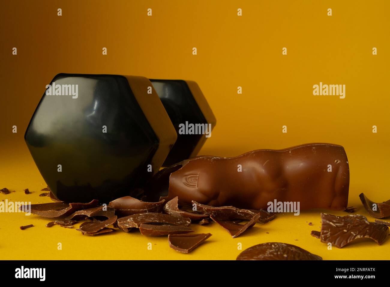 Dumbbell crushing Easter chocolate bunny. Gym workout, fitness exercise ...