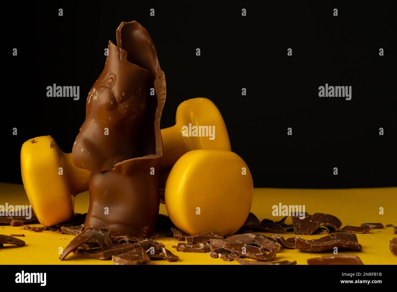 Dumbbell crushing Easter chocolate bunny. Gym workout, fitness exercise ...