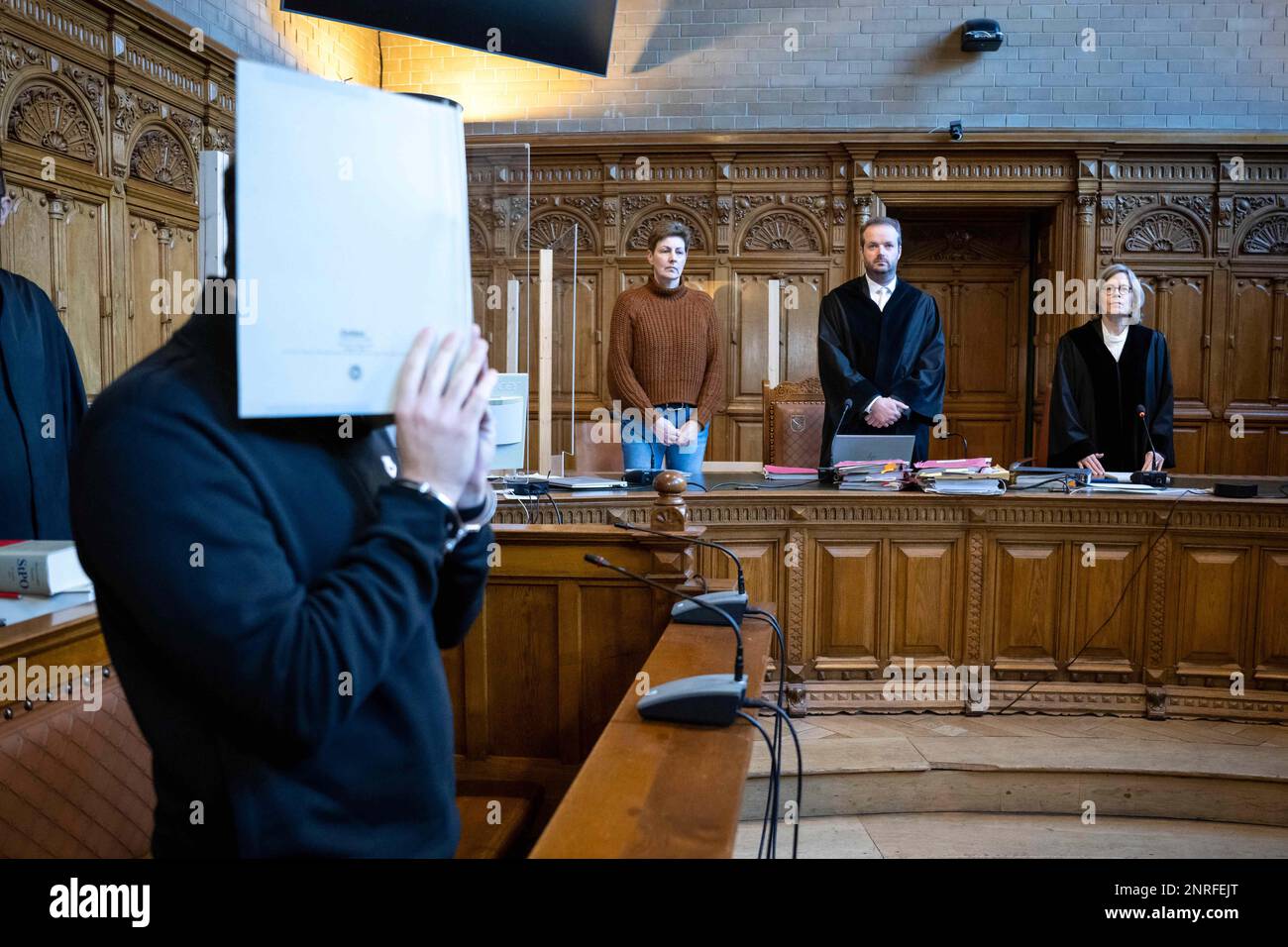 Bremen, Germany. 27th Feb, 2023. The defendant stands in the courtroom ...