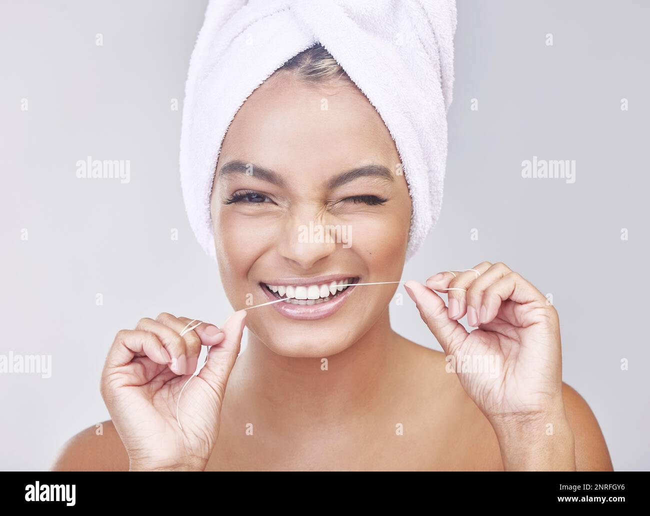 Summer in my mouth. Studio shot of a beautiful young woman flossing her ...