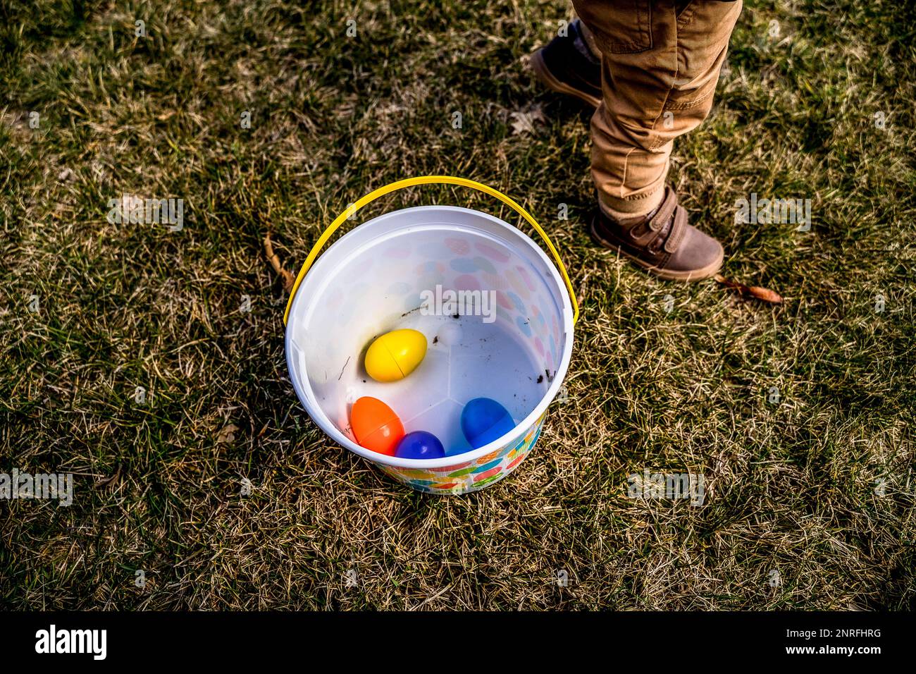 Boy Standing Next to Plastic Bucket Filled with Colorful easter Eggs ...