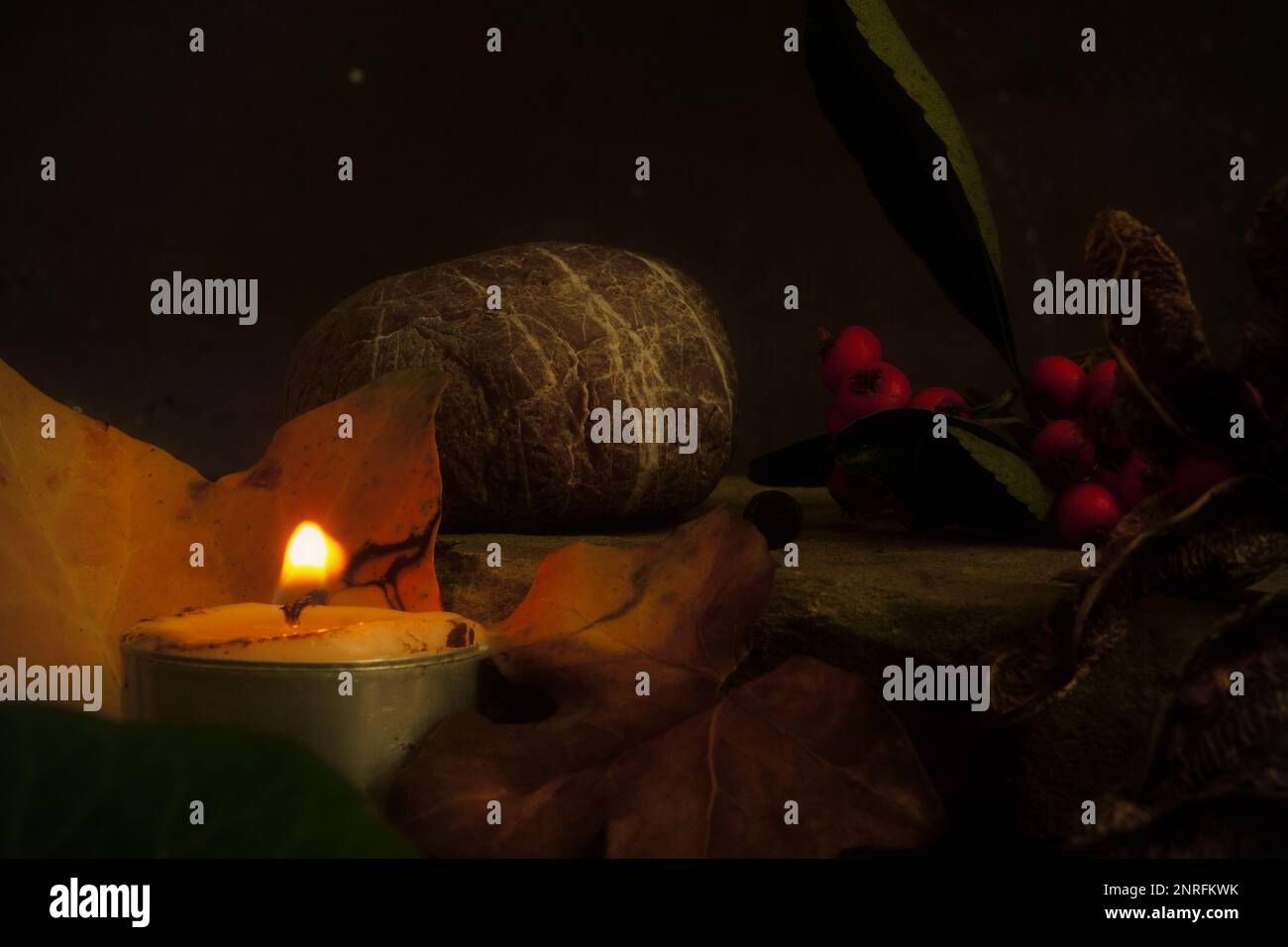 Still life with stone and candle Stock Photo - Alamy