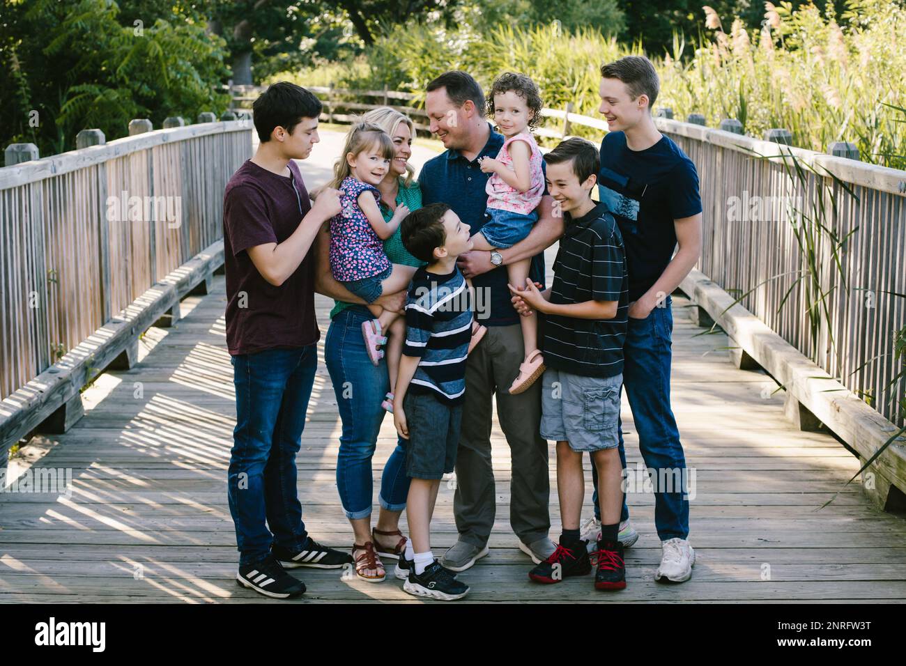 Mother and father smiling with many children happy together outside ...