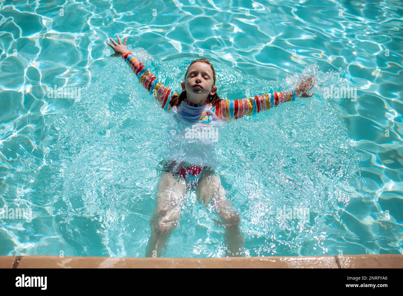 young girl swimming on back in pool on sunny day Stock Photo - Alamy