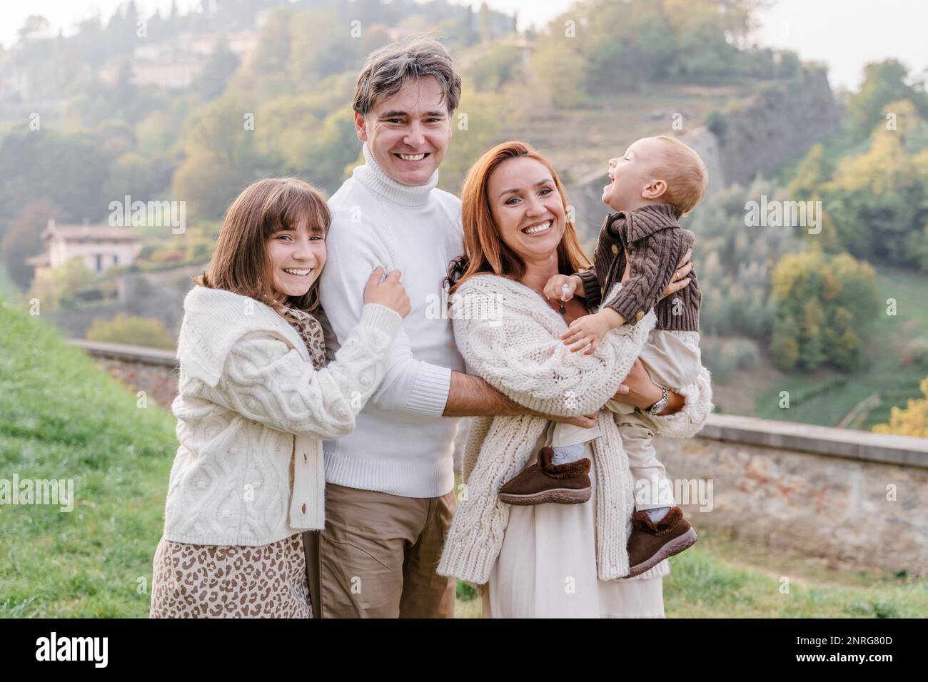 A happy family with two children in a view point of Bergamo, Italy ...