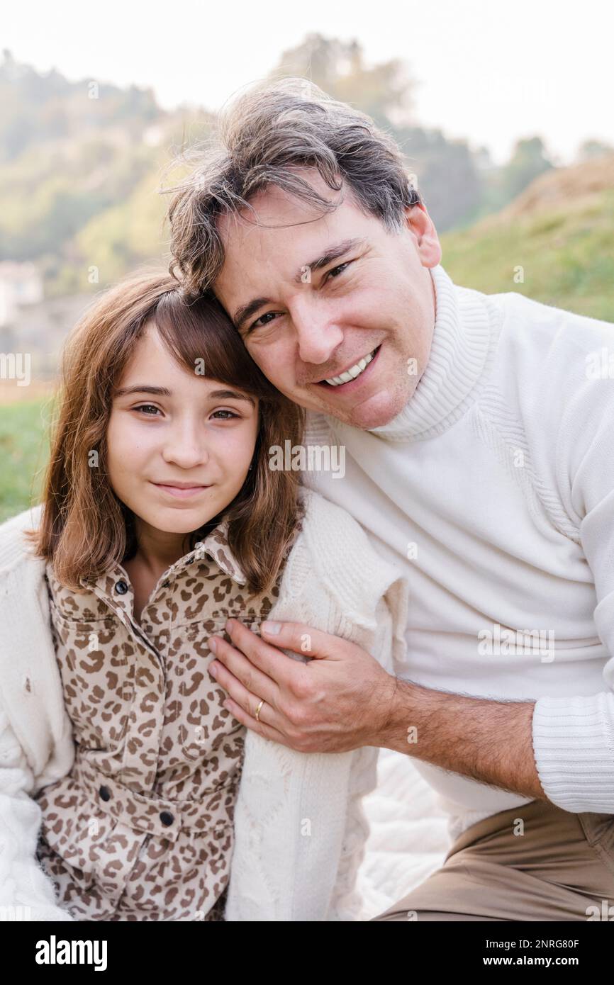 A man and teenage daughter are hugging and smiling outdoors Stock Photo ...