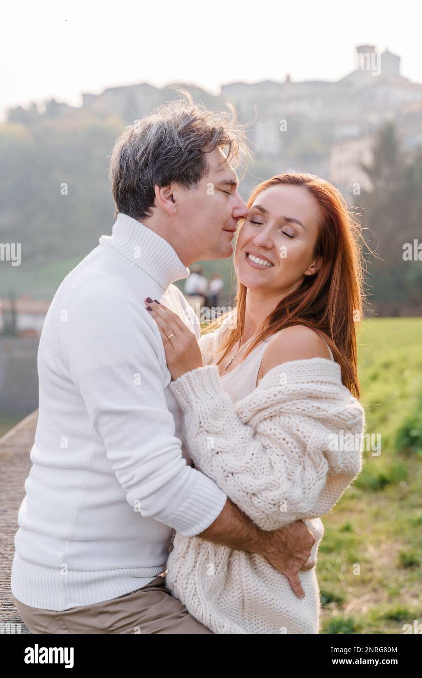 A loving couple hugging, a man gently kisses a woman Stock Photo - Alamy