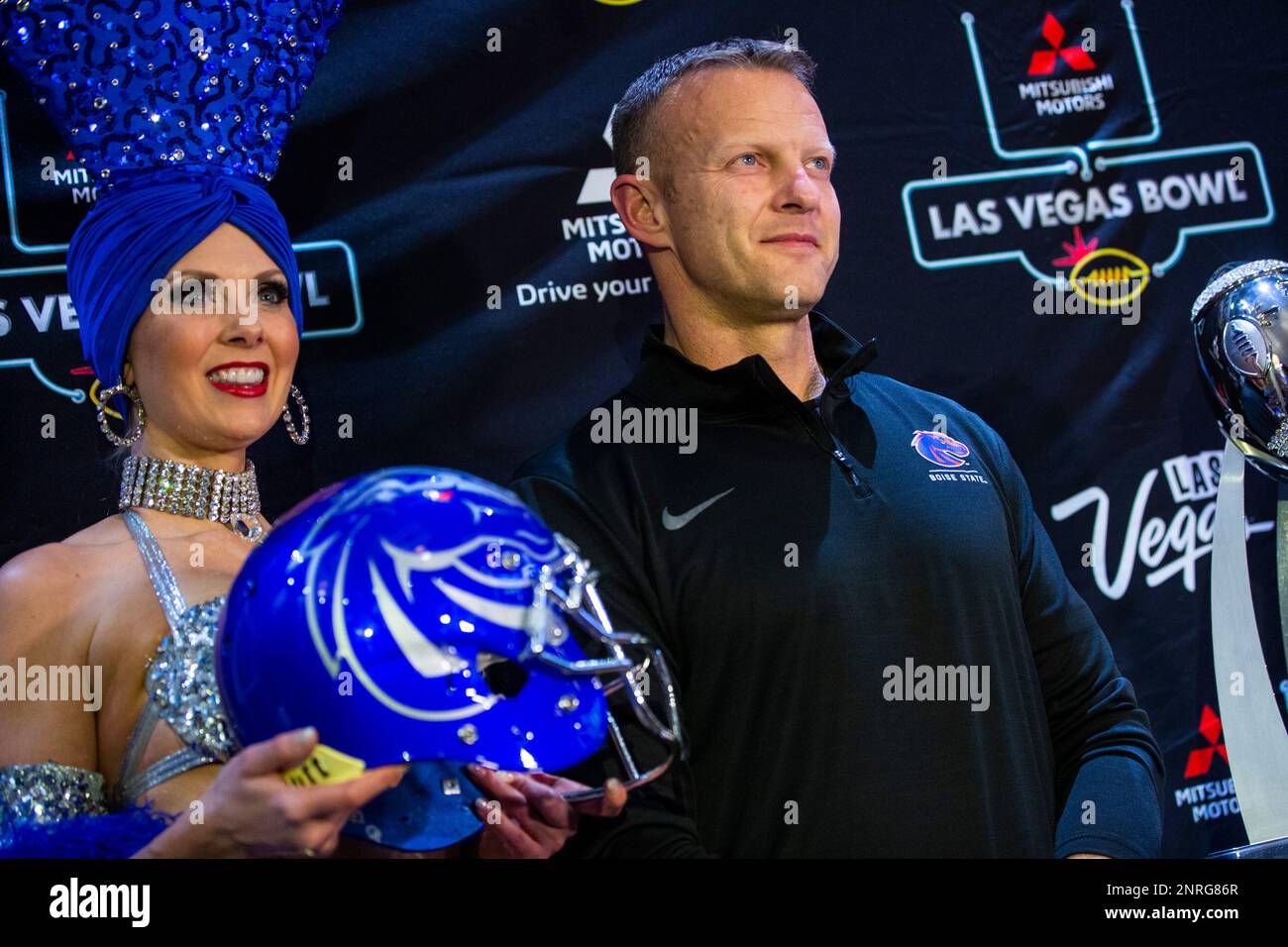 Boise State head coach Bryan Harsin poses alongside showgirl Jennifer Autry ahead of the Las ...