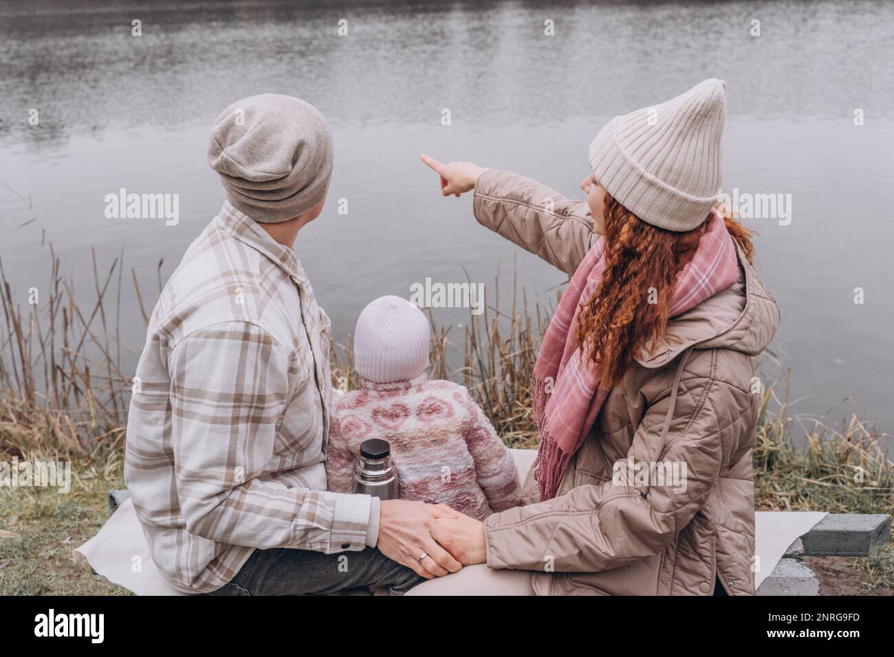 Family with a small child resting near the river in cold weather Stock ...