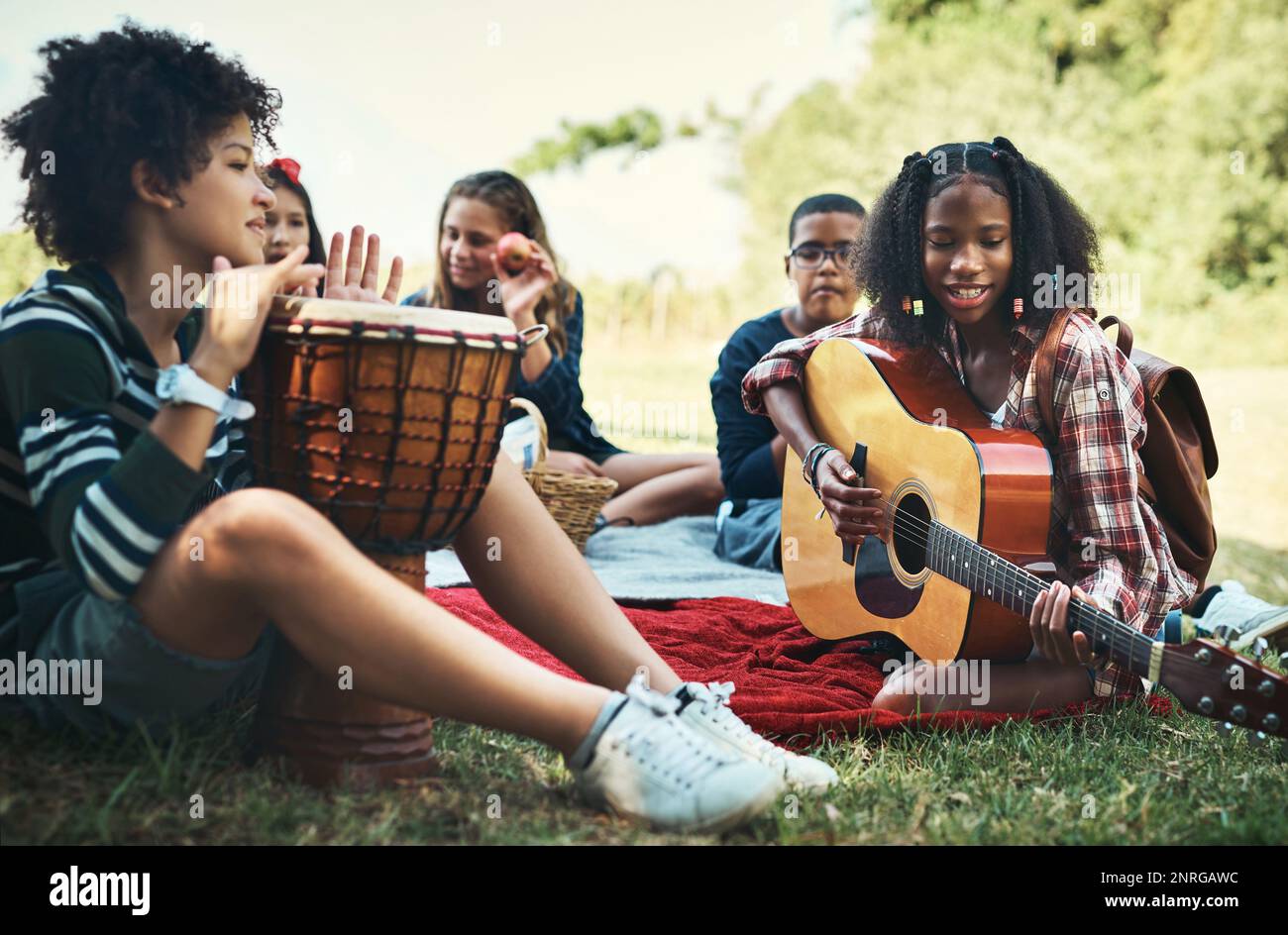 Gather round for a good jam sesh. a group of teenagers playing musical ...