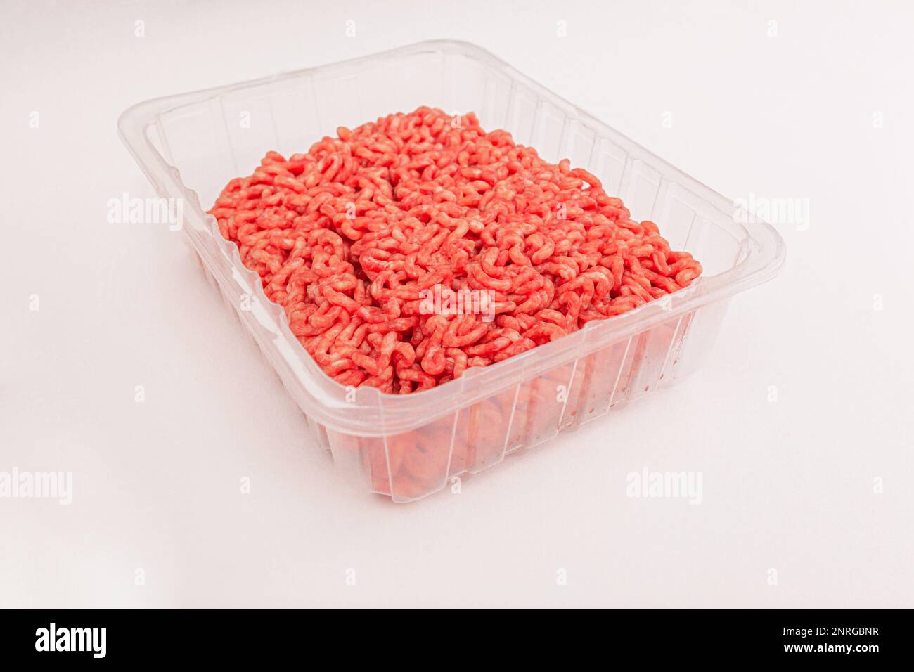 Minced meat in plastic container on white background Stock Photo - Alamy