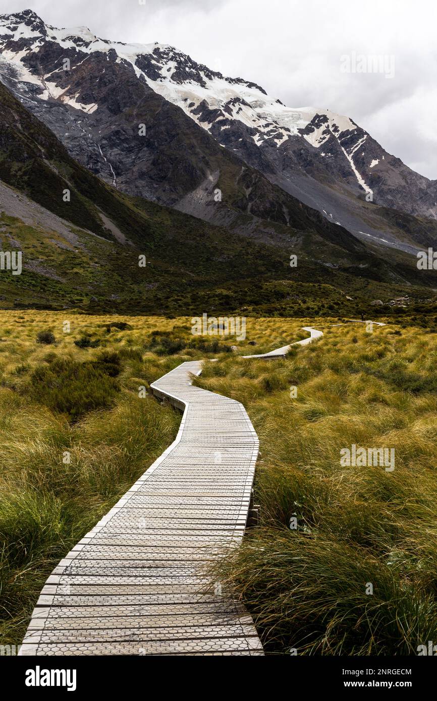 An outdoor boardwalk leading into a majestic mountain landscape, with ...