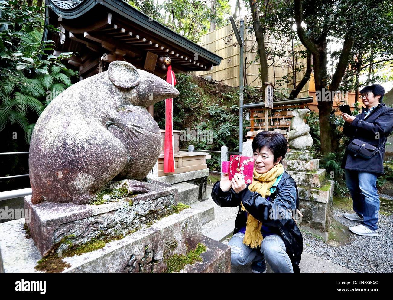 Visitors take pictures of a rat statue at Otoyo Jinja Shrine in Kyoto ...