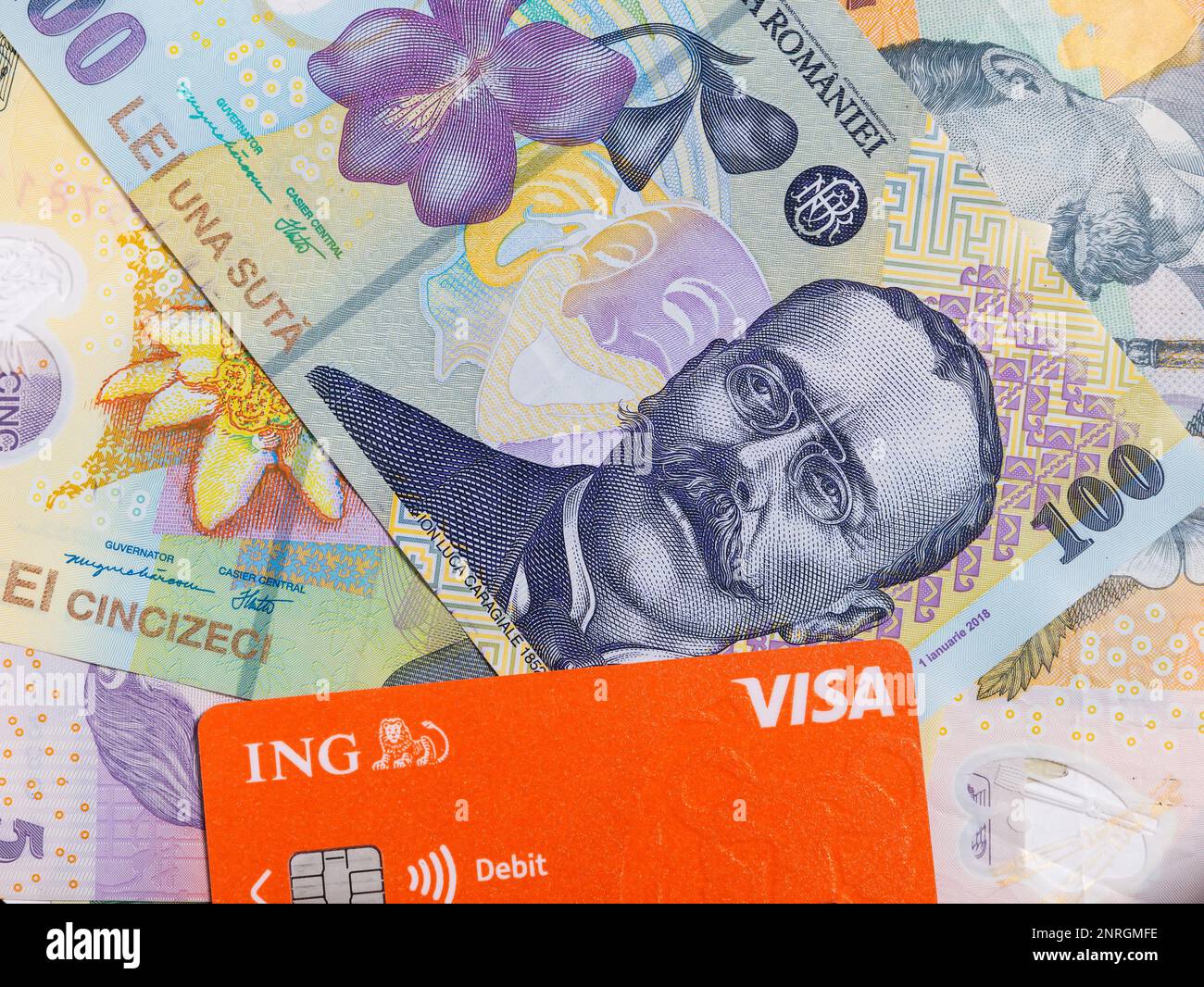 ING debit card and many romanian banknotes on black background ...