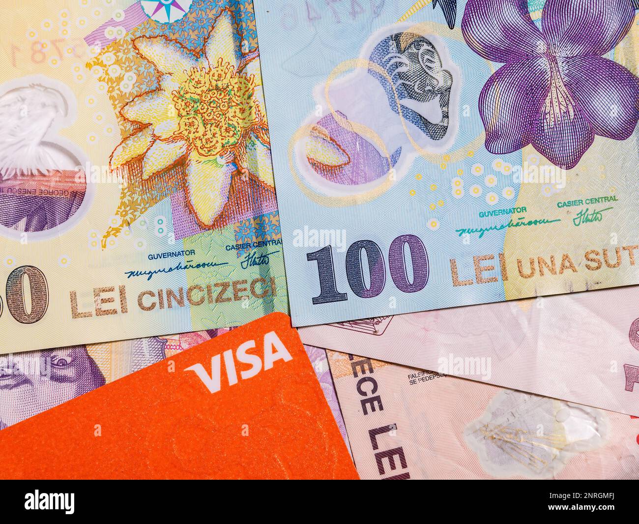 Visa debit or credit card and many romanian banknotes on black ...