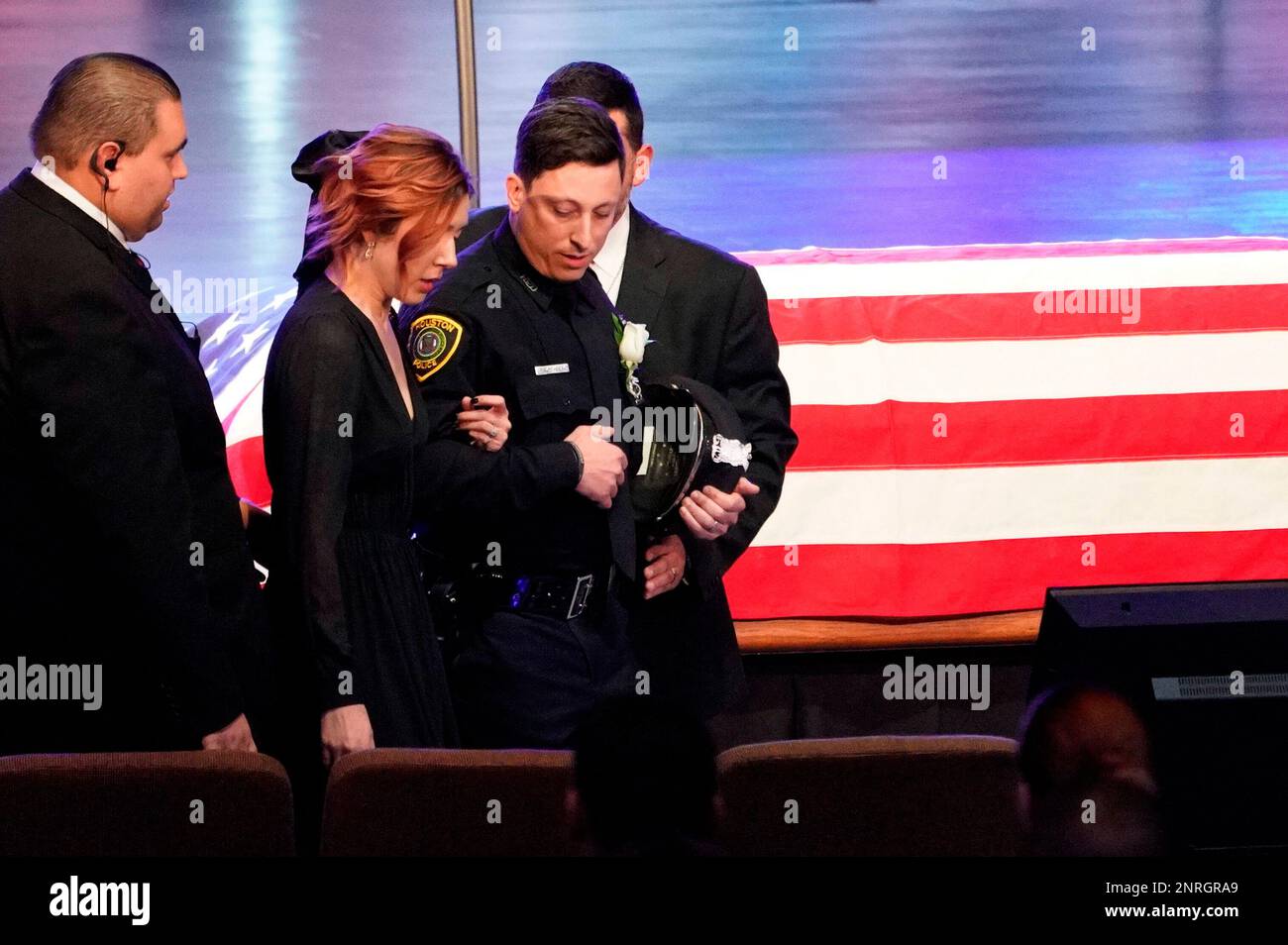 Widow Bethany Elise Brewster is escorted into the church sanctuary for ...