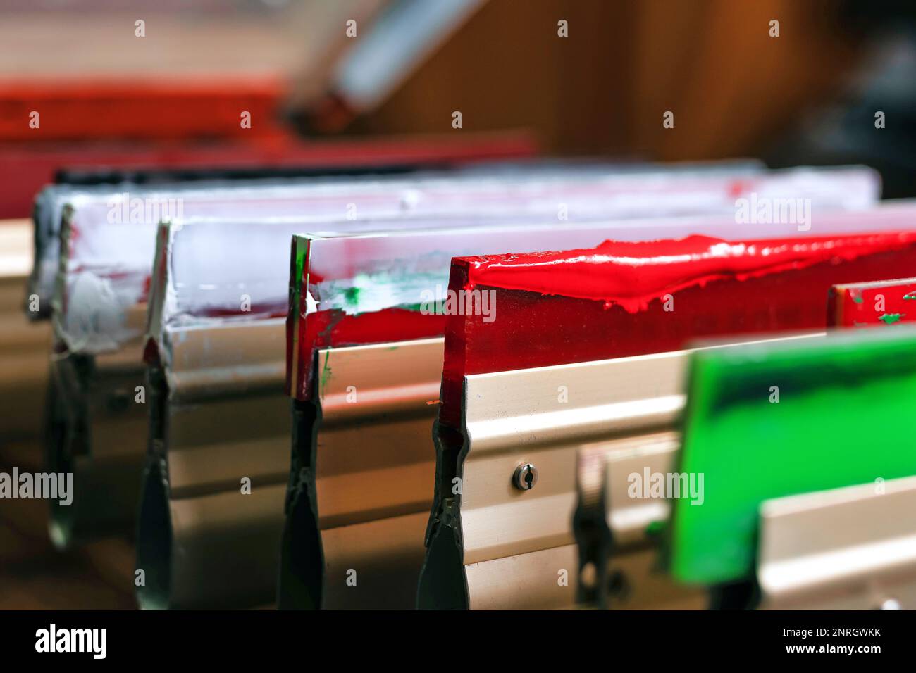 squeegees close-up on wooden shelve of the print screening apparatus ...