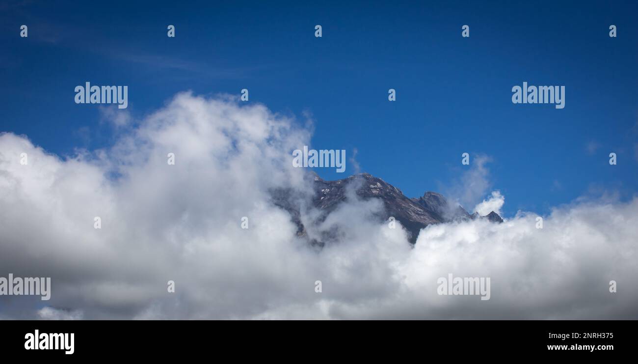 Peak of Mount Kinabalu in background as clouds cover the rest of the ...