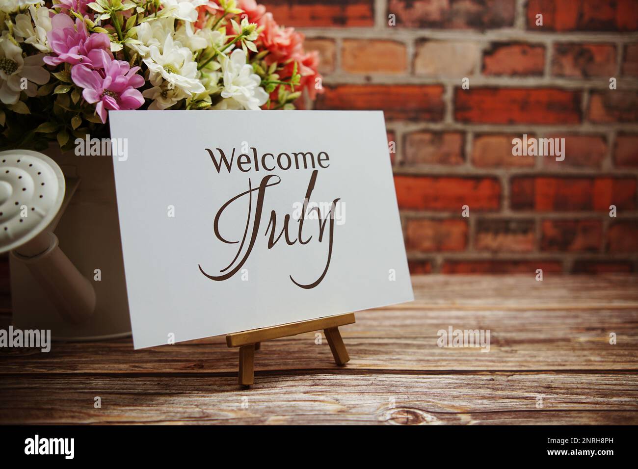 Welcome July text with flower bouquet decoration on wooden and old ...