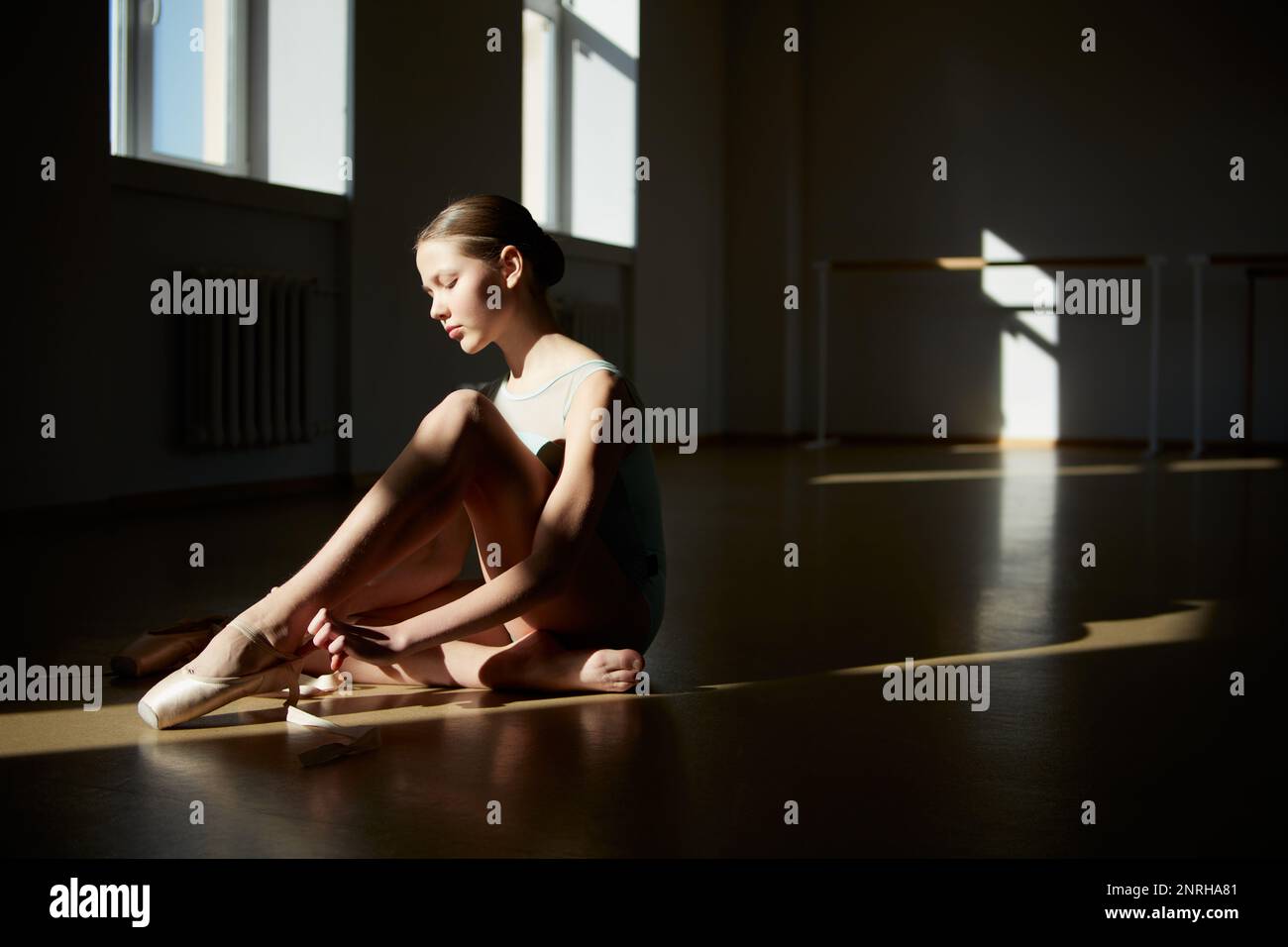 Young tender teen girl, classical ballet dancer getting ready to train ...