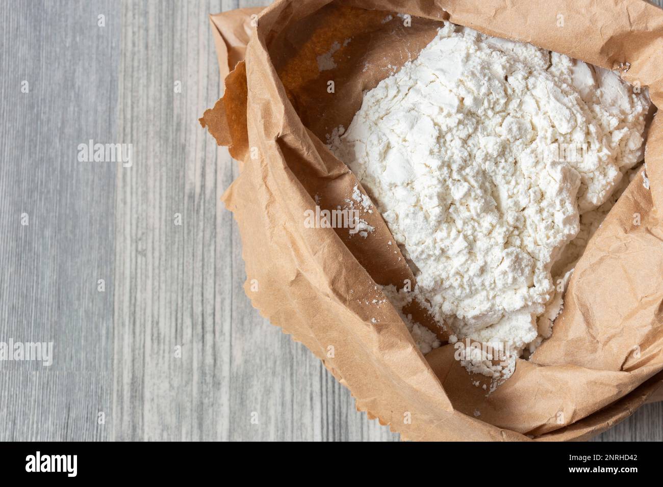 Plain white flour in a brown paper bag on grey wood. Eco friendly ...