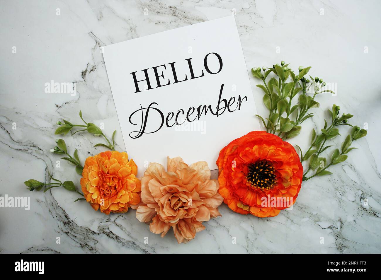 Hello December text with orange flower bouquet on marble background ...