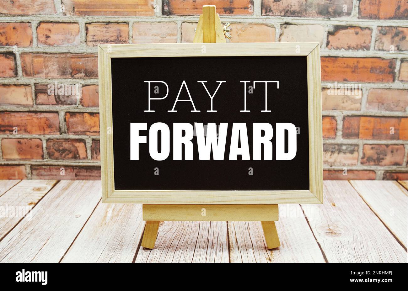 Pay It Forward typography text on the blackboard set on wooden floor ...