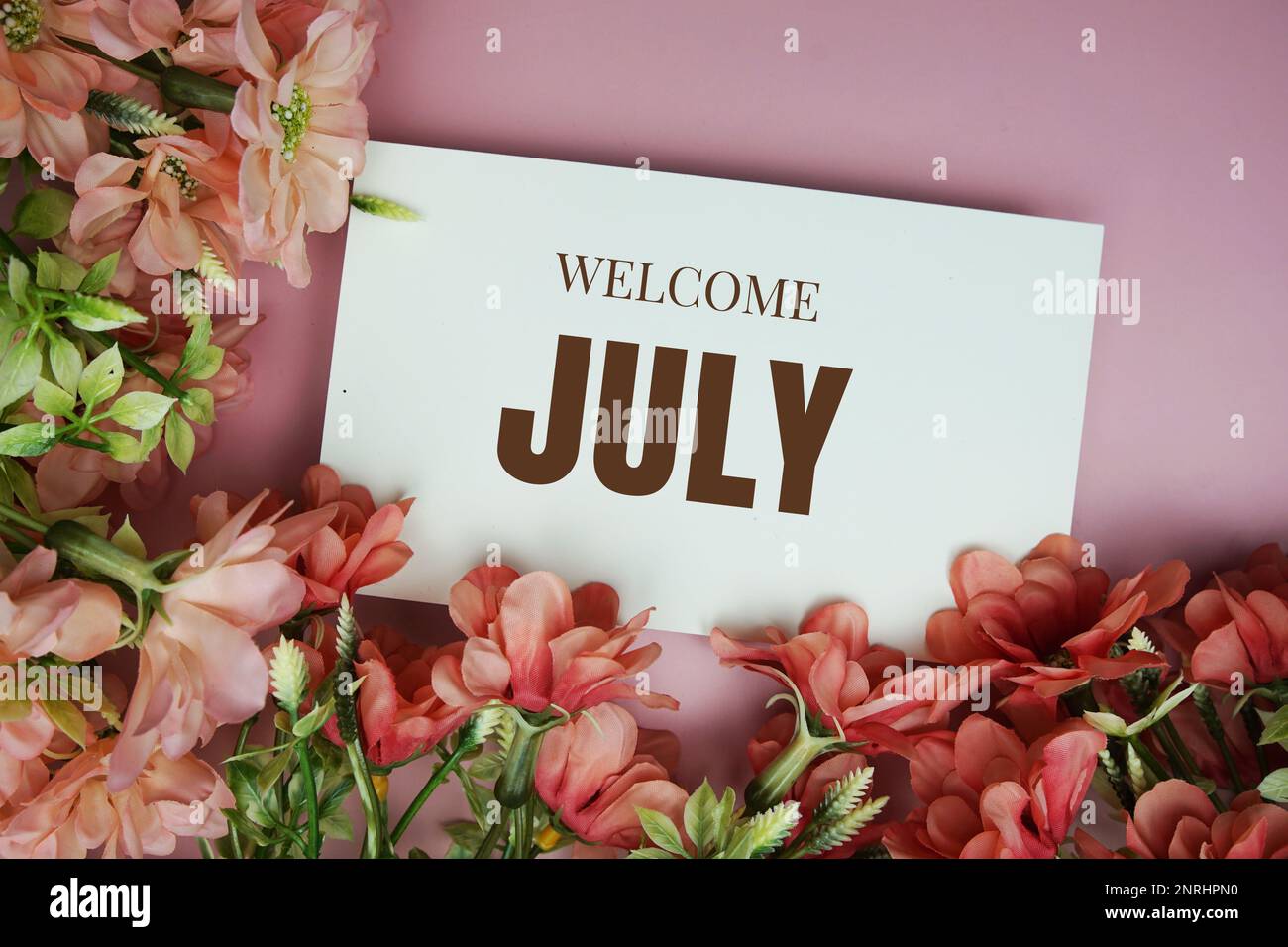Welcome July typography text with flowers frame on pink background ...