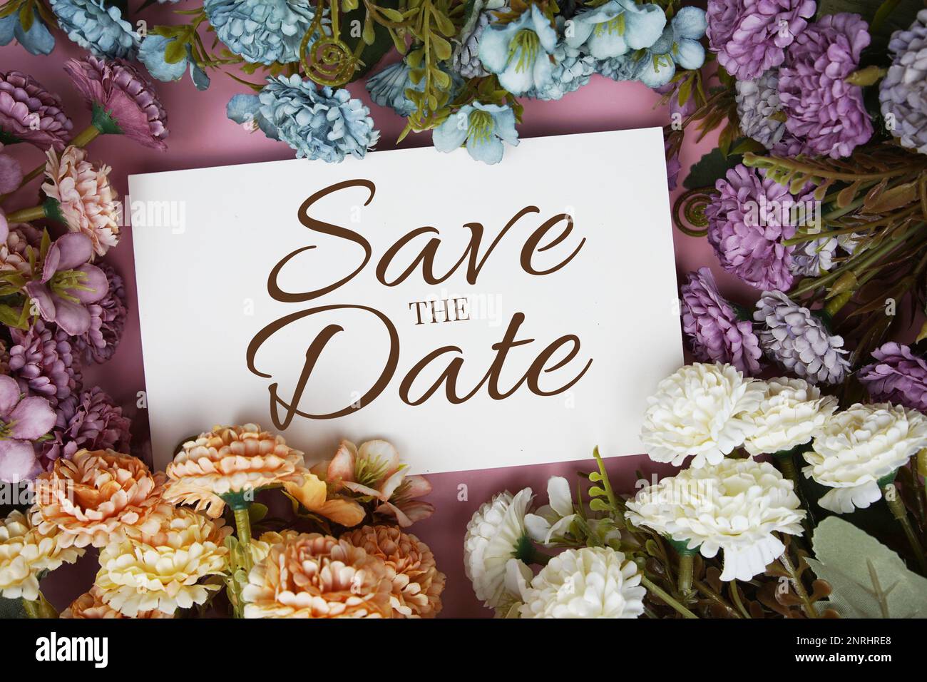Save the Date typography text with flowers frame on pink background ...