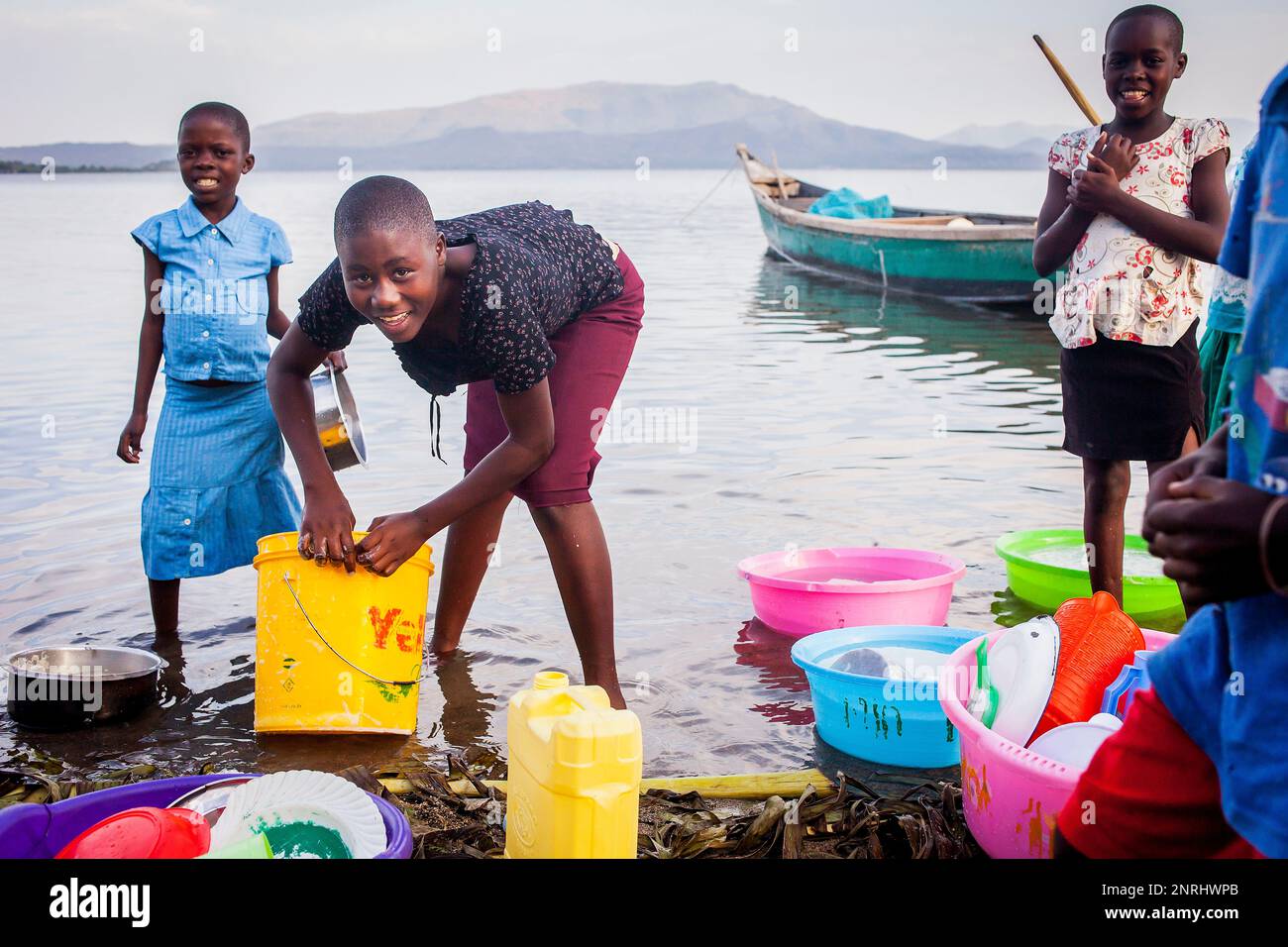 Girls washing cooking utensils, in the fishing village of Kolunga ...