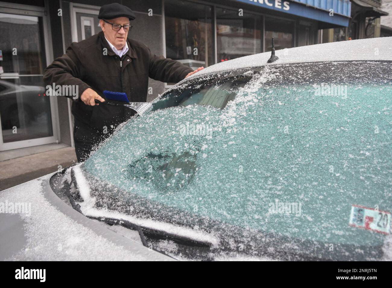 Paul Ciotti, of Minersville, Pa., scrapes ice off of his car windshield ...