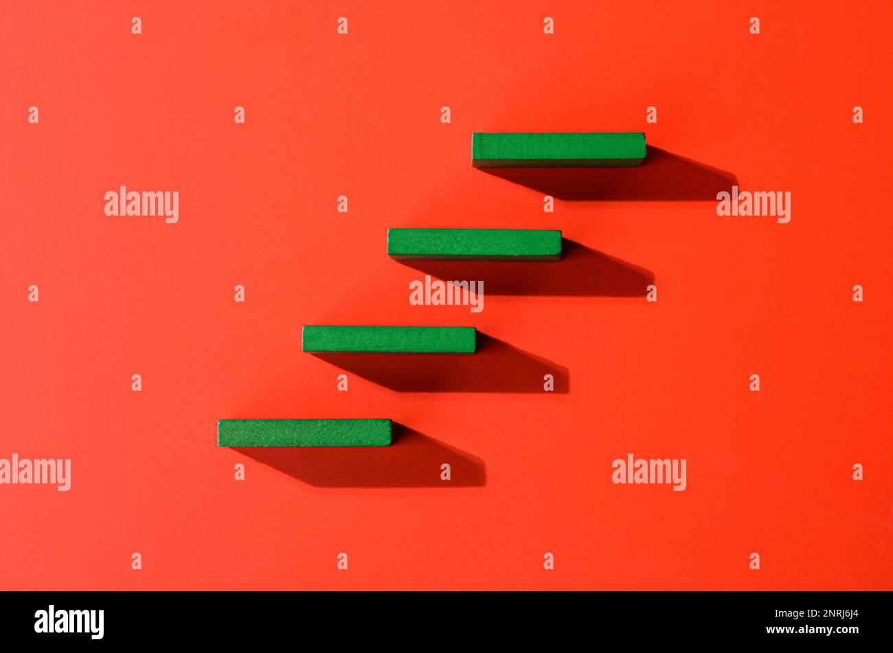 Steps to success. Green steps on red background Stock Photo - Alamy