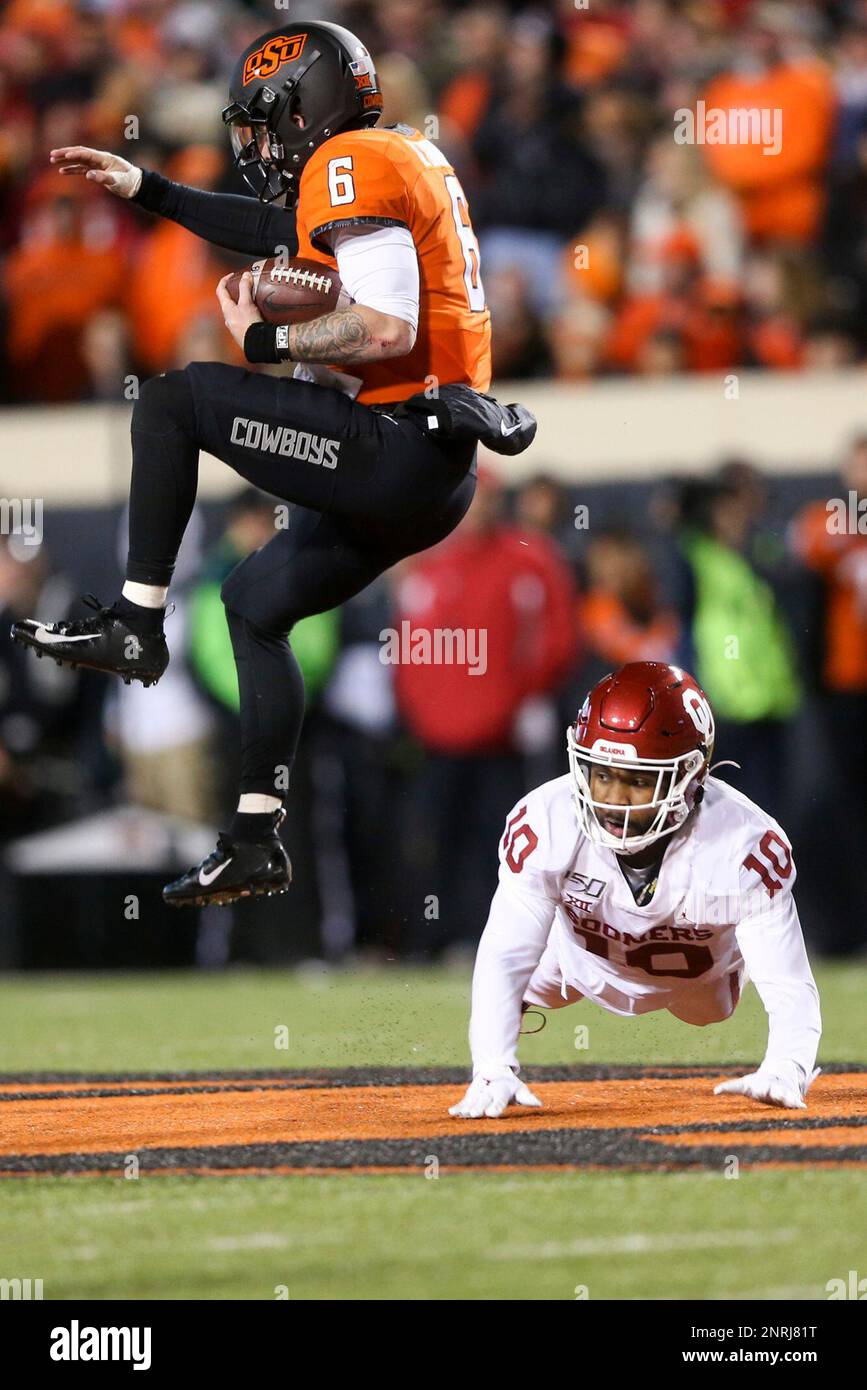 Oklahoma State quarterback Dru Brown (6) leaps over Oklahoma safety Pat ...
