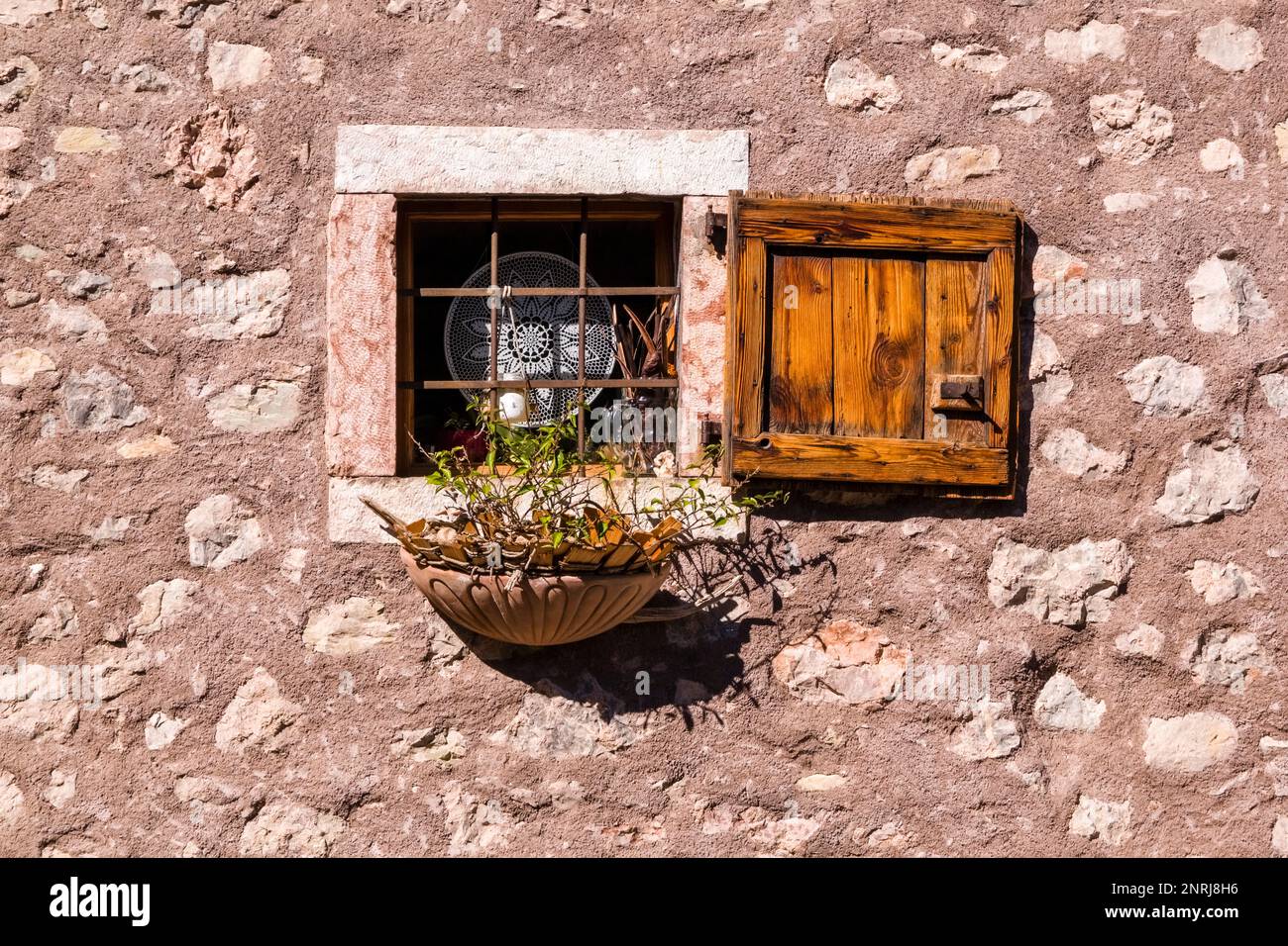 Small window in the stone wall of a traditional farmhouse in a small ...