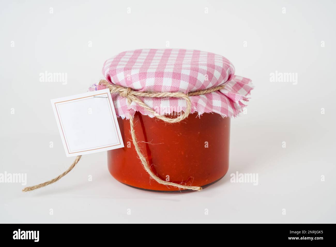Canned homemade tomato paste jar with empty label isolated on white ...