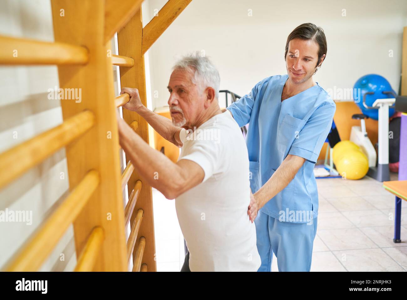 Senior man with male physiotherapist guiding in exercise at ...