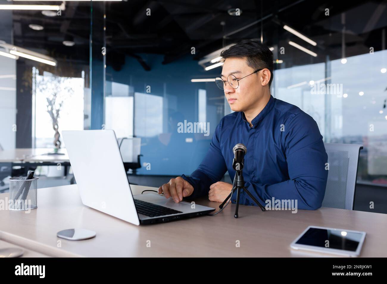 Serious teacher recording online business course at workplace inside ...