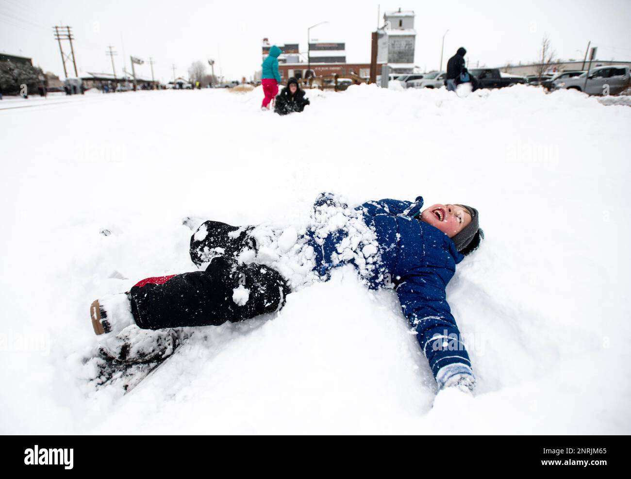 Jonathan Mclane, 5, giggles as he lays in the snow while making a snow ...