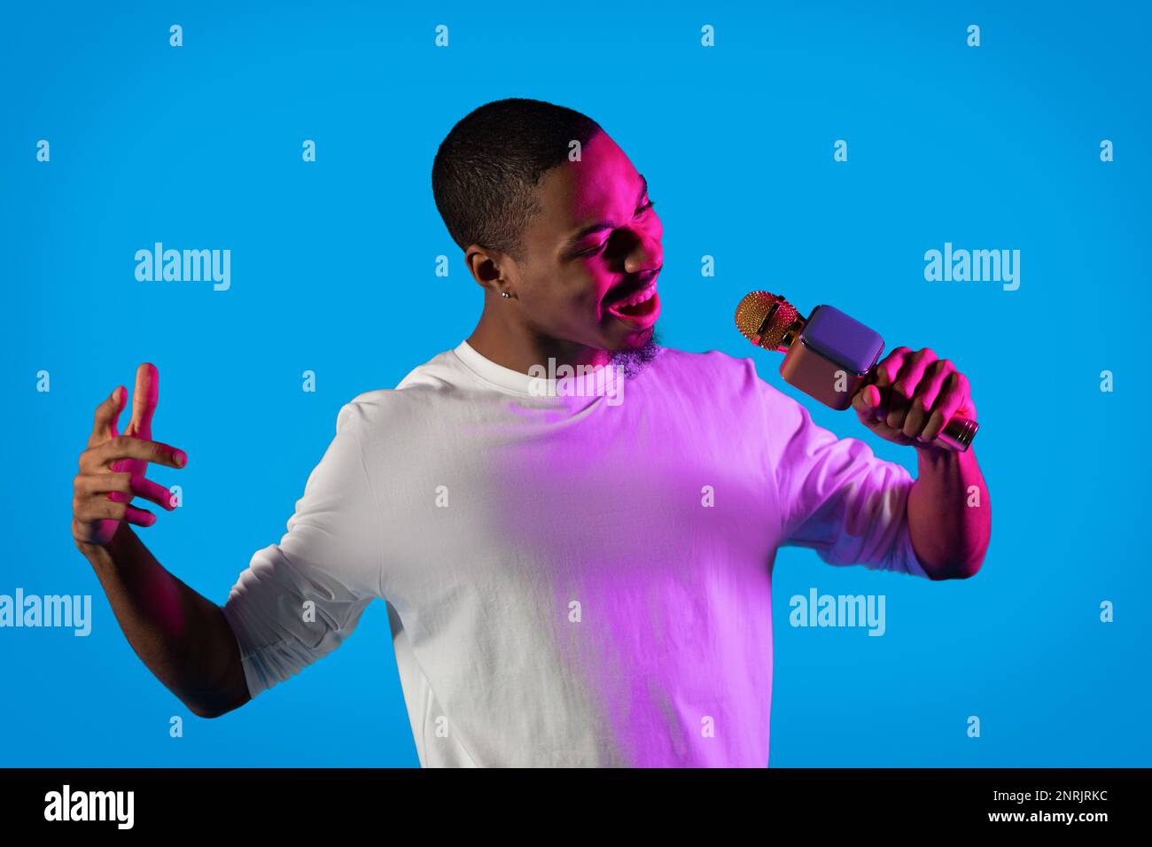 Cool black guy rapper singer performing on blue Stock Photo - Alamy