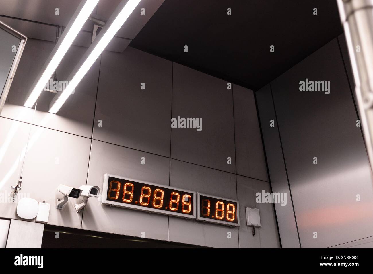 display of digital clock and video cameras on wall over railway tracks ...