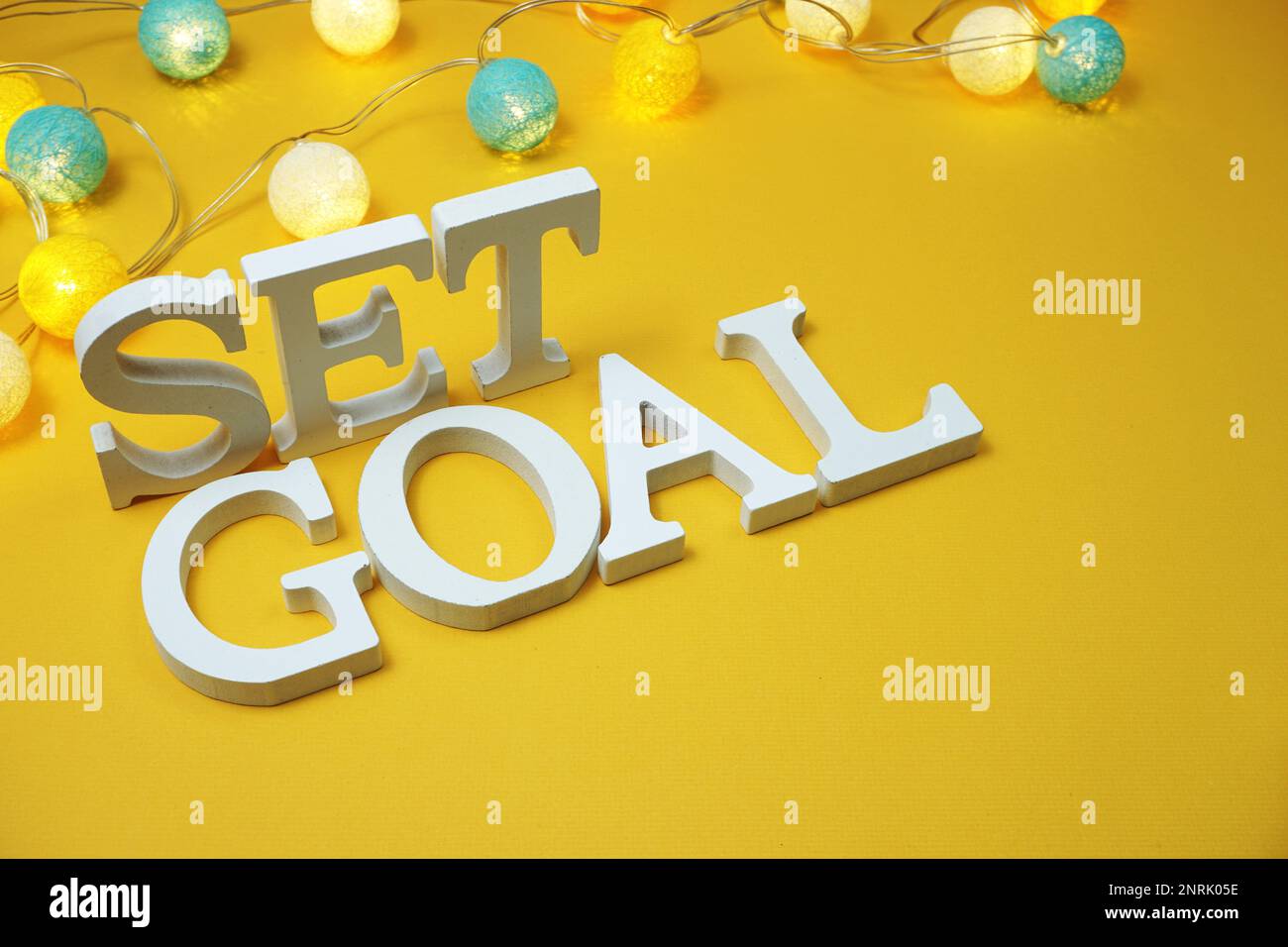 Set Goal alphabet letter with LED cotton balls on yellow background ...