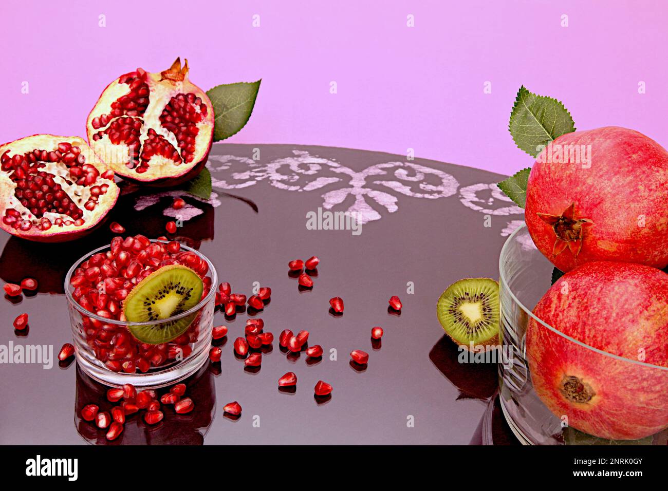 This image features red fruit on a table with kiwi, pears and other ...