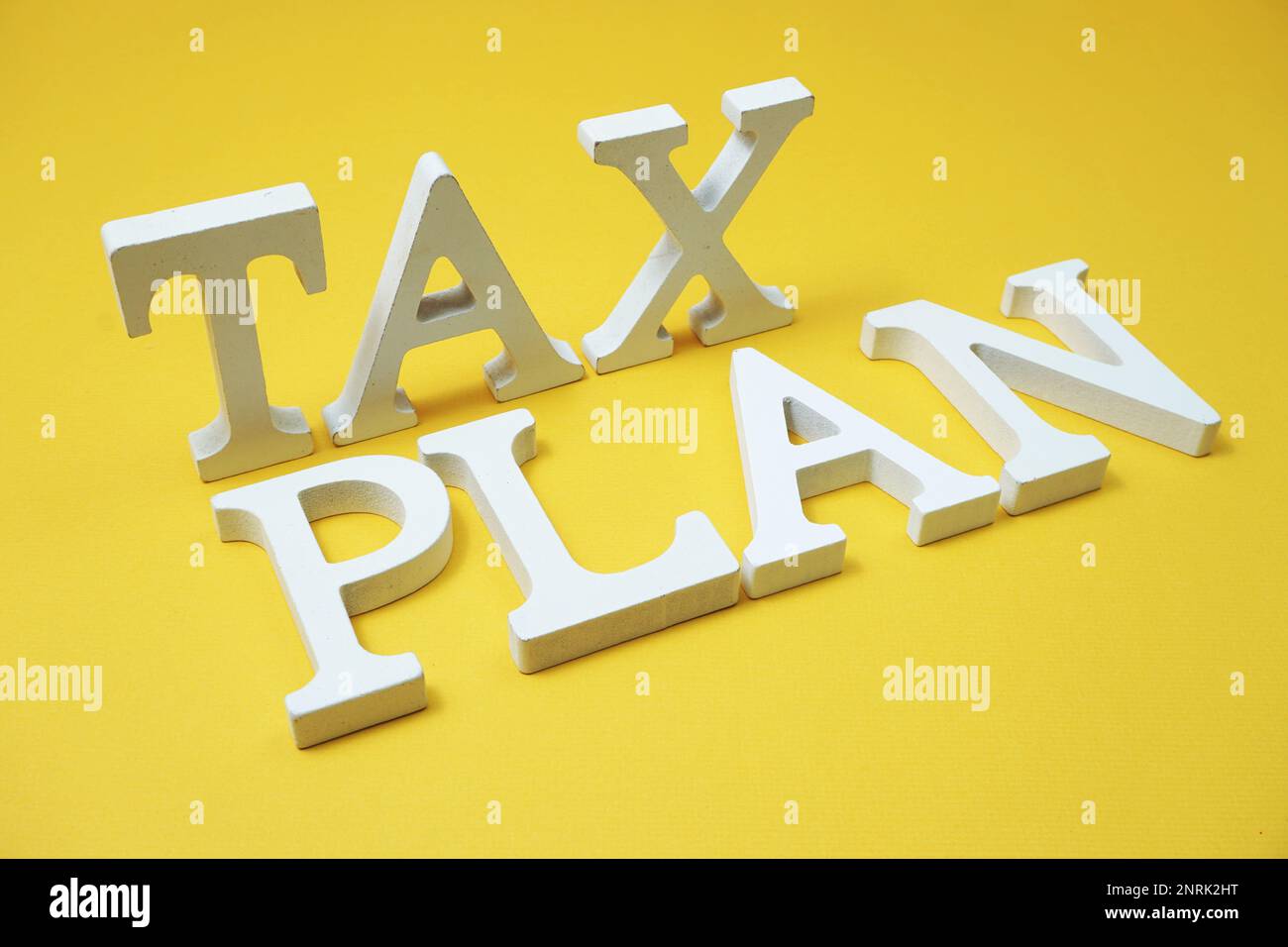 Tax Plan alphabet letters on yellow background Stock Photo - Alamy